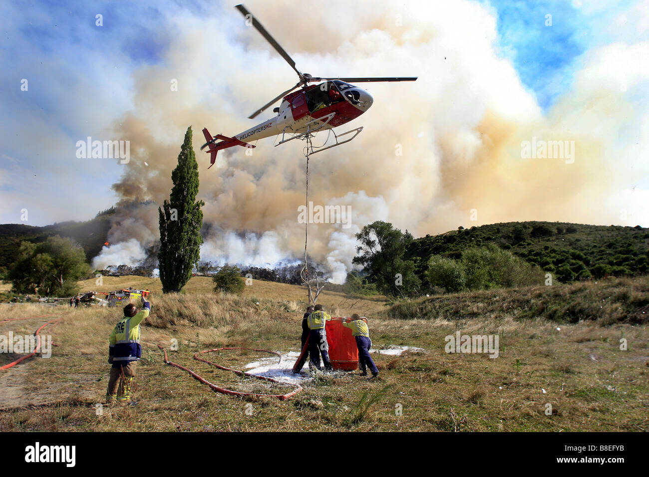 firefighters fill the monsoon bucket for a helicopter fighting a ...