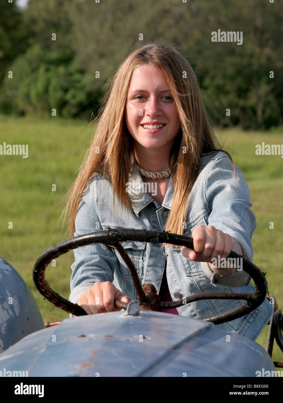A beautiful farmer s daughter behind the wheel of an antique tractor ...