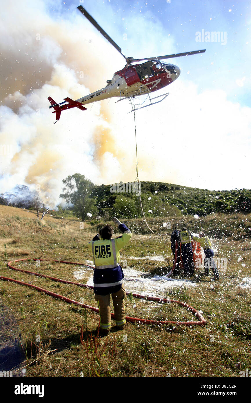 firefighters fill the monsoon bucket of a helicopter fighting a bush ...