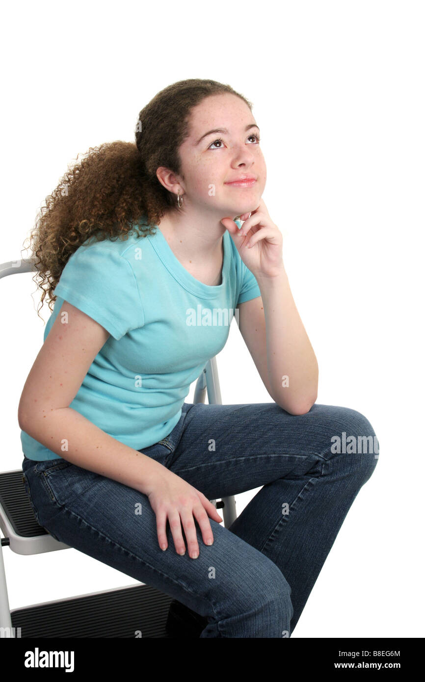 A pretty teen girl sitting on a stool lost in thought Stock Photo - Alamy