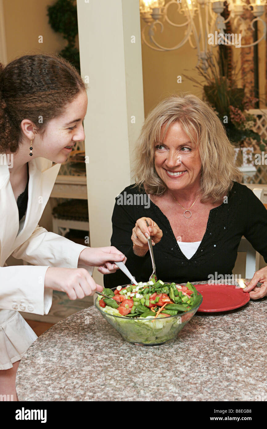 A woman and a teen digging in to a healthy salad for lunch Stock Photo ...