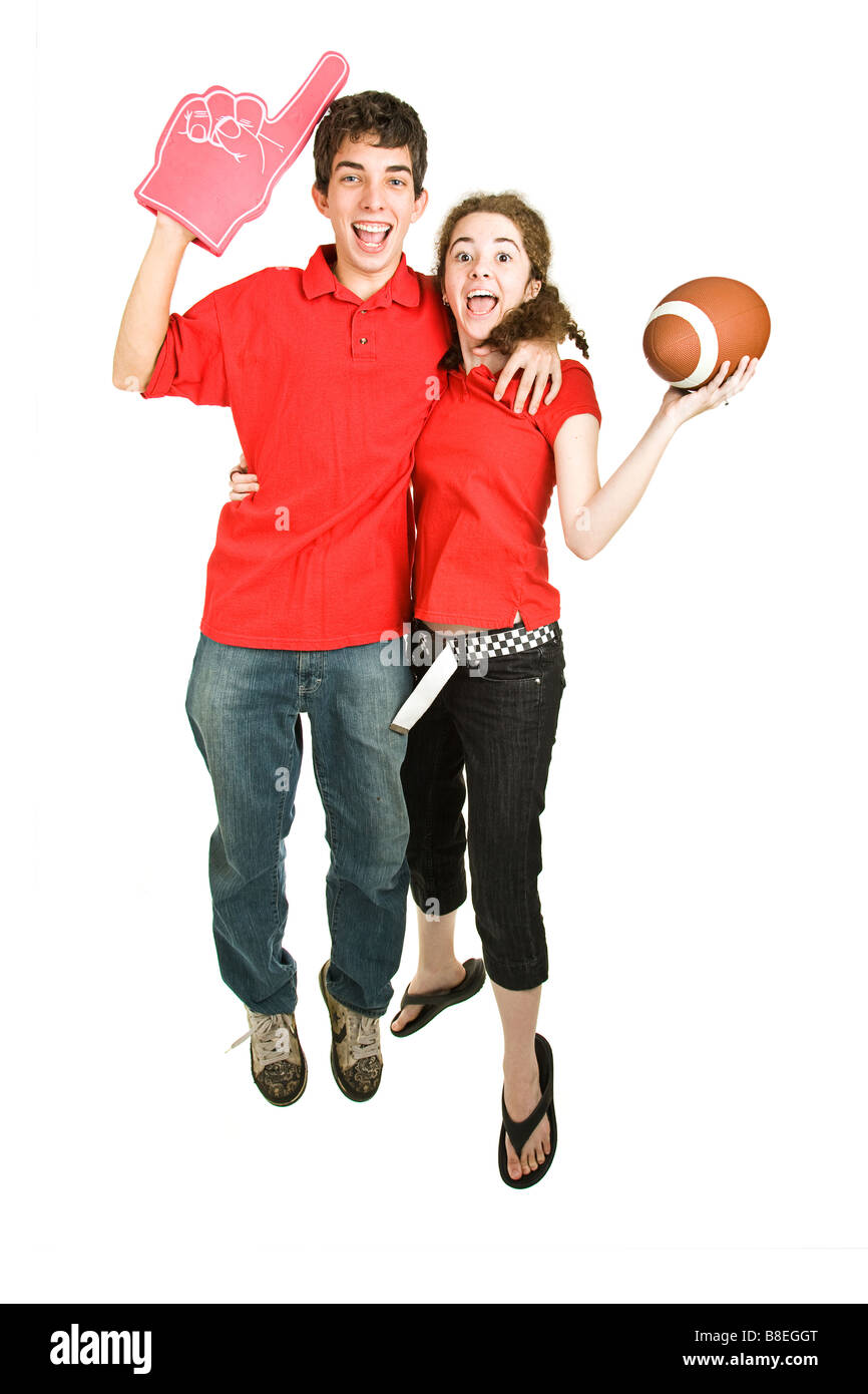Two enthusiastic teen football fans jumping for joy Full body isolated ...