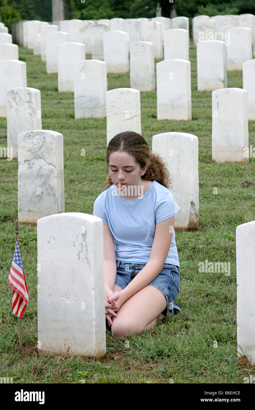 a young girl mourning a fallen soldier in a graveyard Stock Photo - Alamy