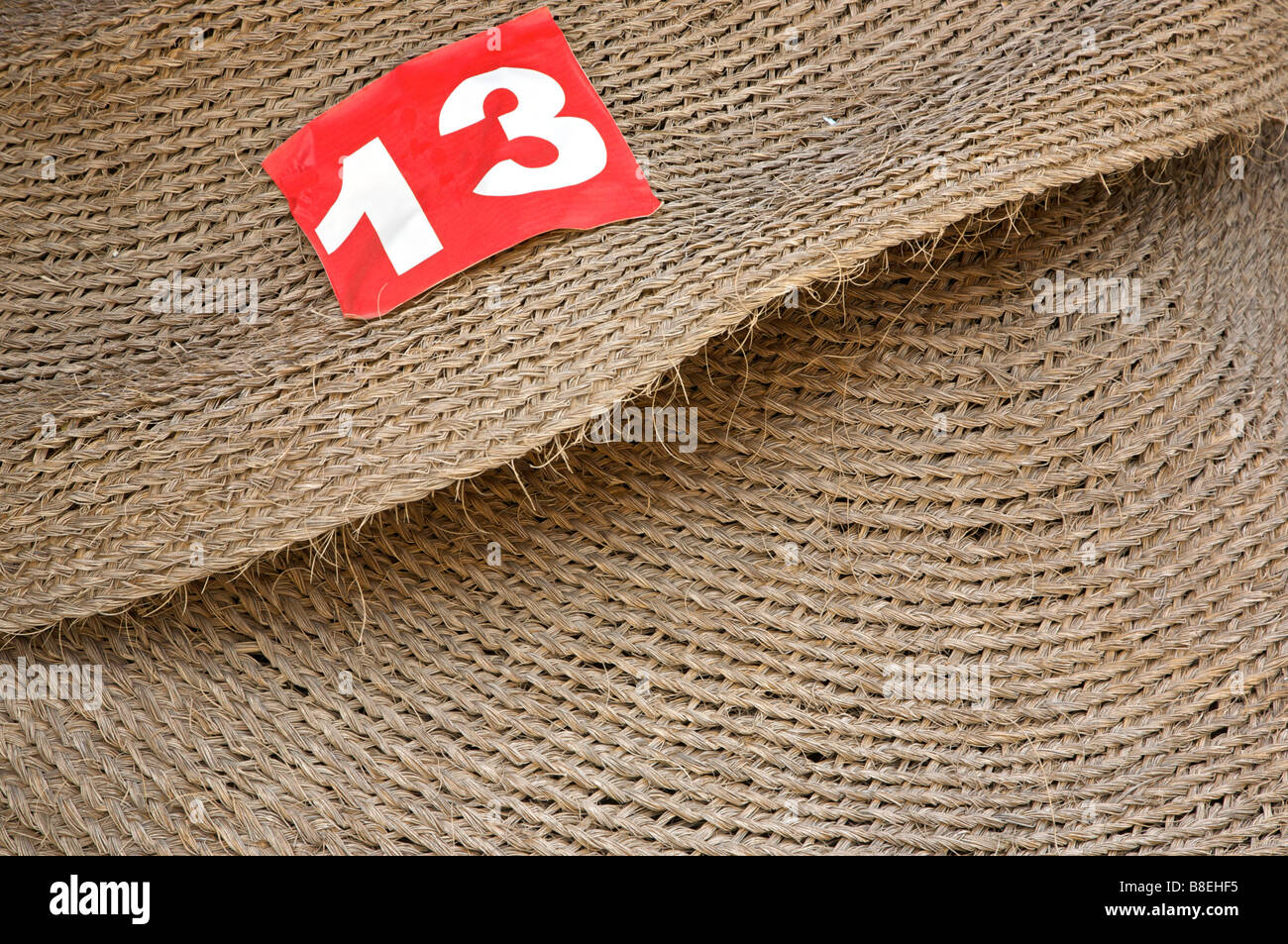Number 13 on square red label attached to straw hats Stock Photo - Alamy