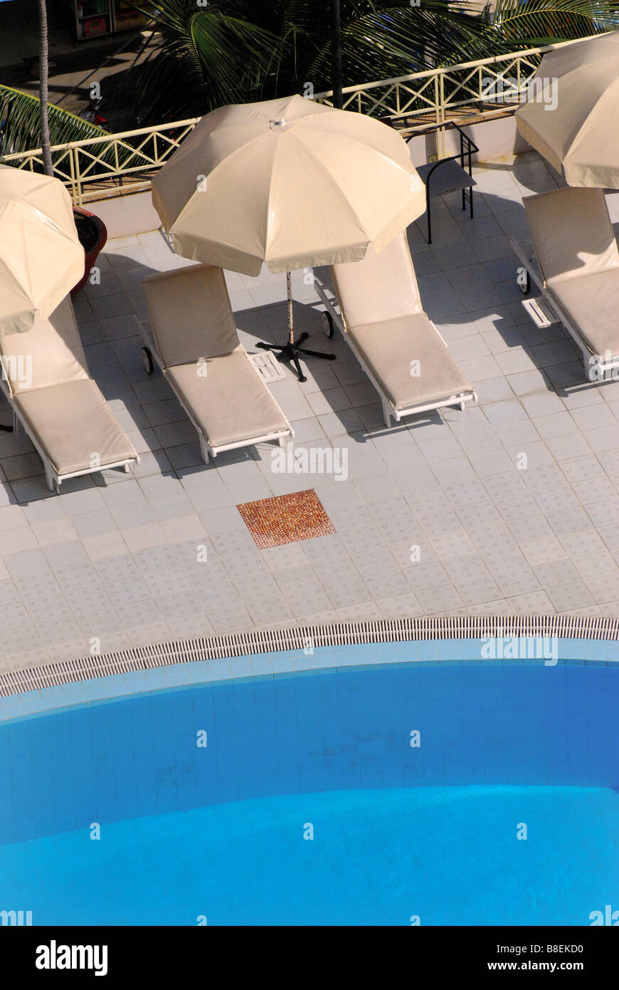 Blue swimming pool with beige beach umbrellas Stock Photo - Alamy
