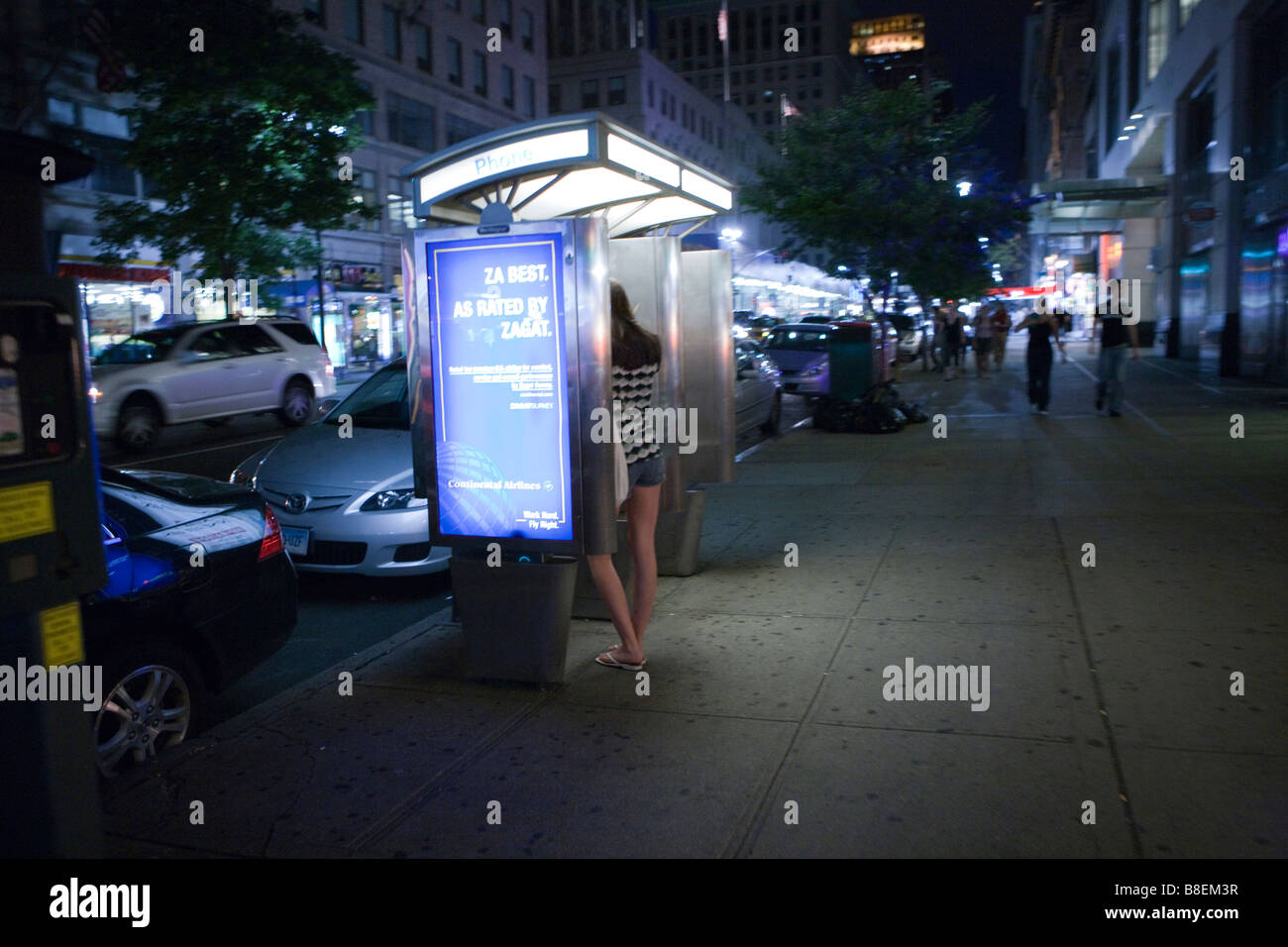 Young woman using a payphone on street at night Stock Photo - Alamy