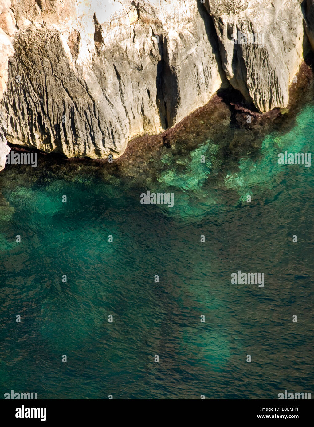 Deep clear emerald sea next to coastal cliff Stock Photo - Alamy