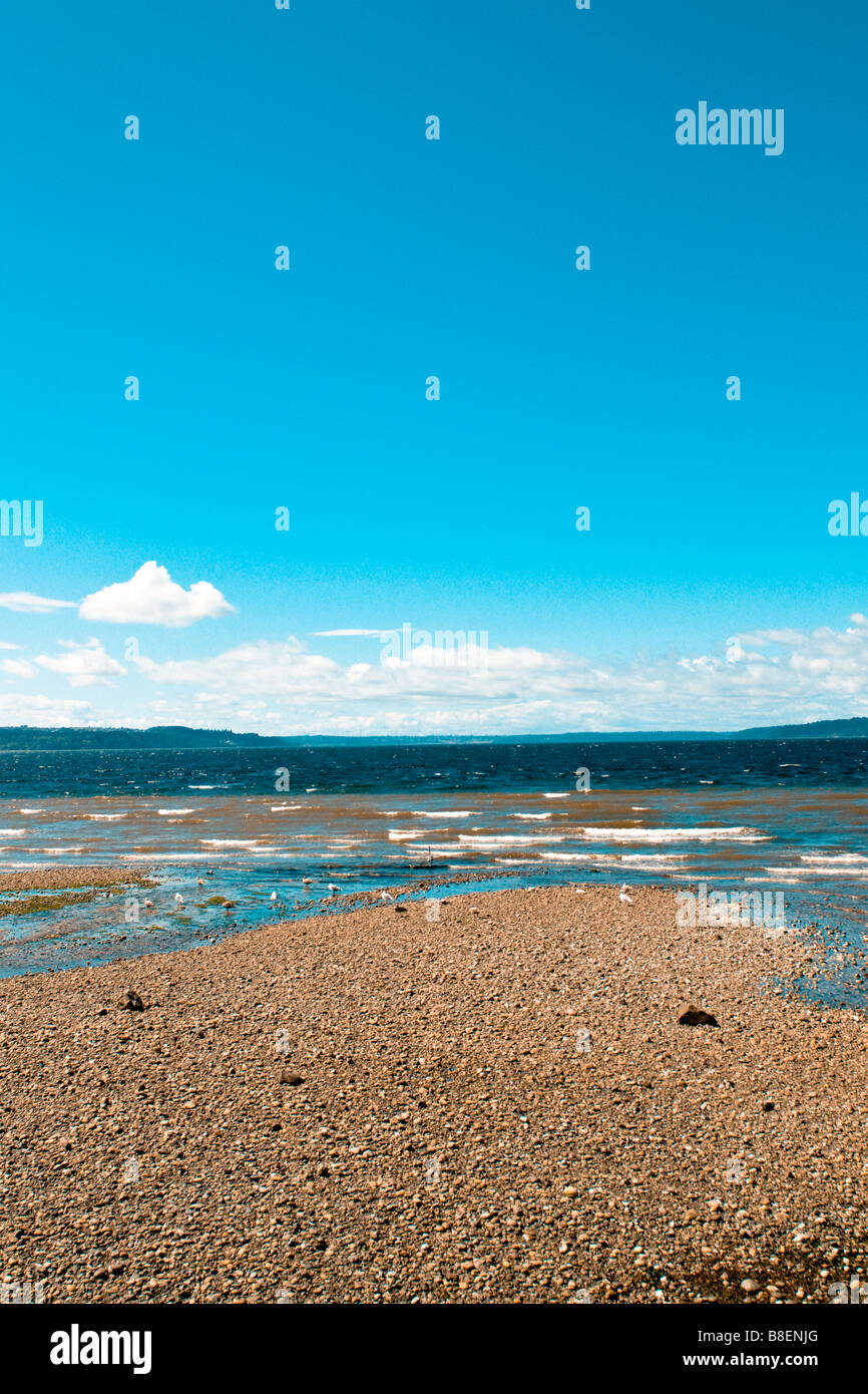 Small waves lapping a stony beach on the shores of Puget Sound just ...