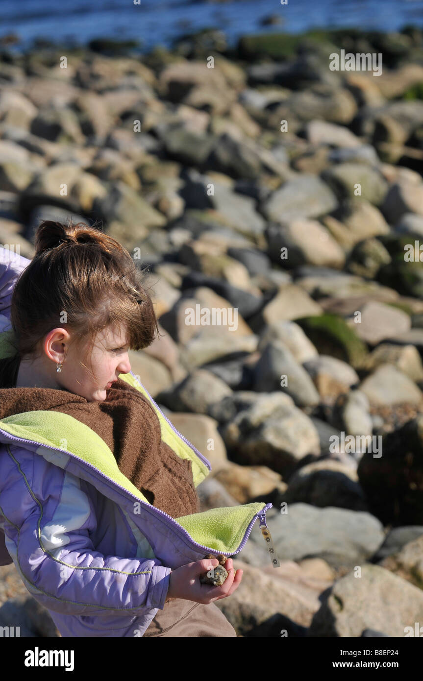 Youing girl getting ready to throw rock into water Stock Photo - Alamy