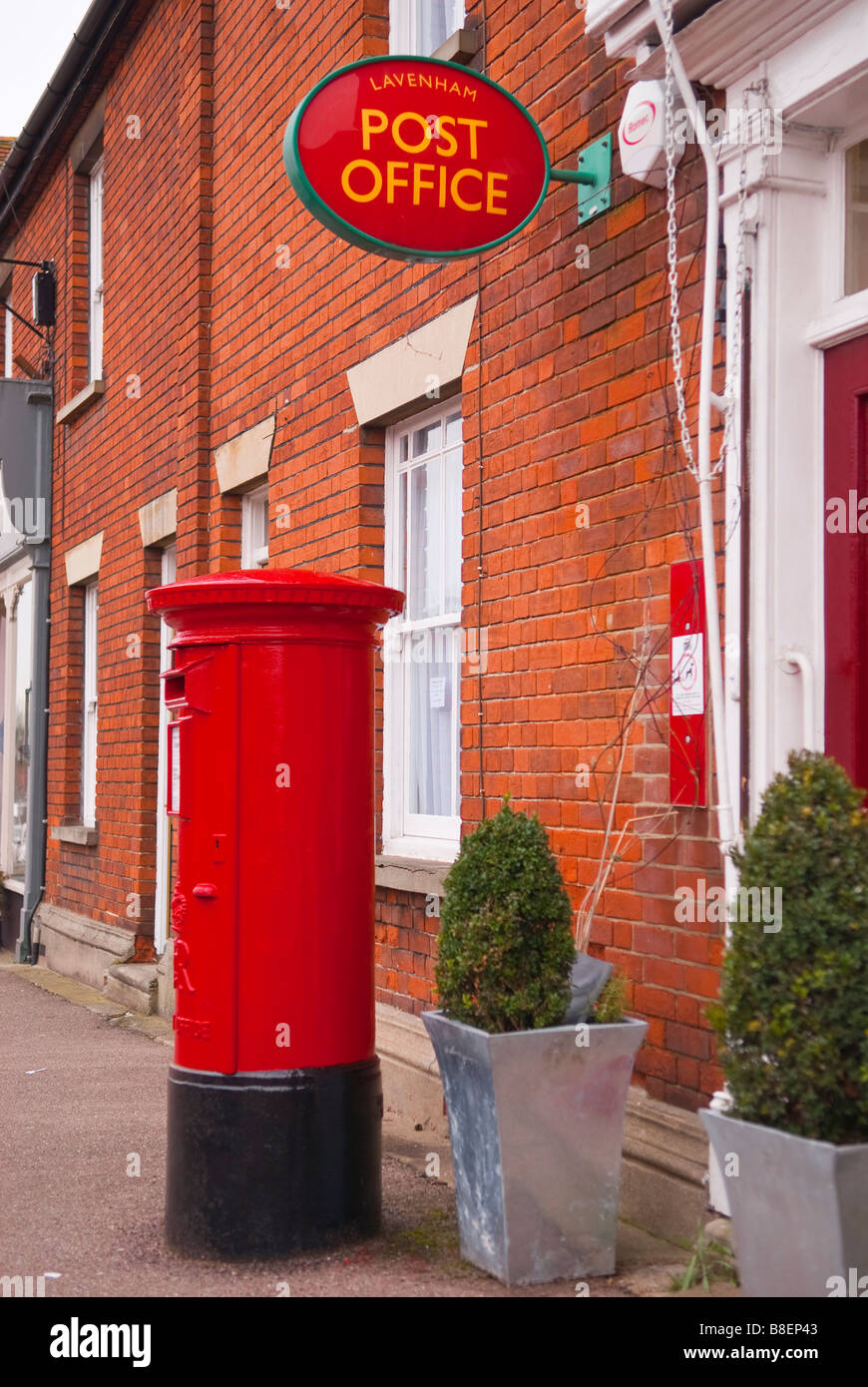 A royal mail postbox and sign at the village post office in Lavenham ...
