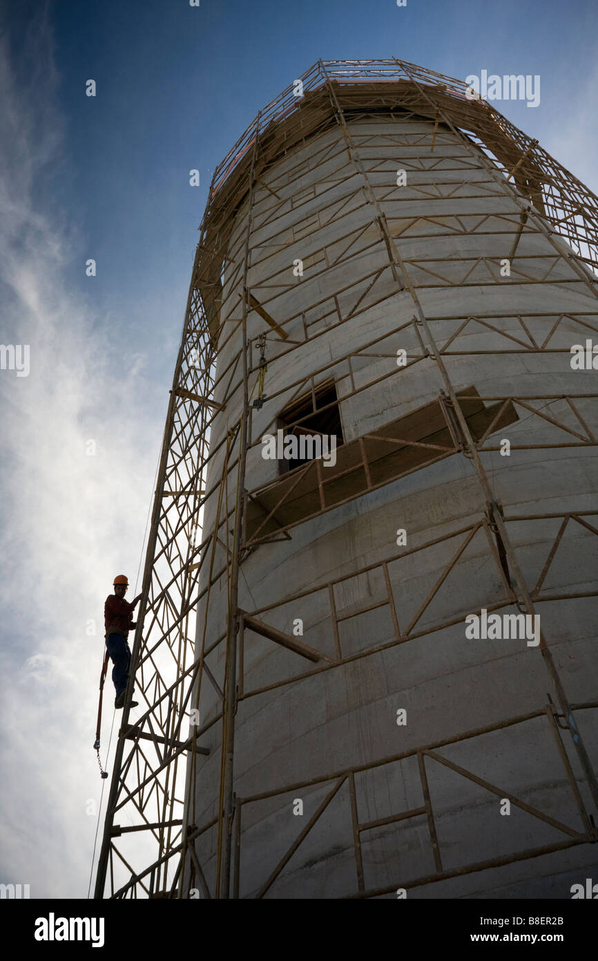 man climbing a tower still being built Stock Photo - Alamy