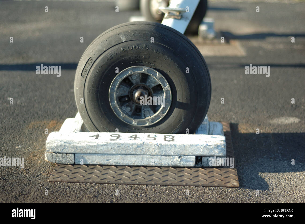 A small single engine airplane tire secured by wood blocks while parked ...
