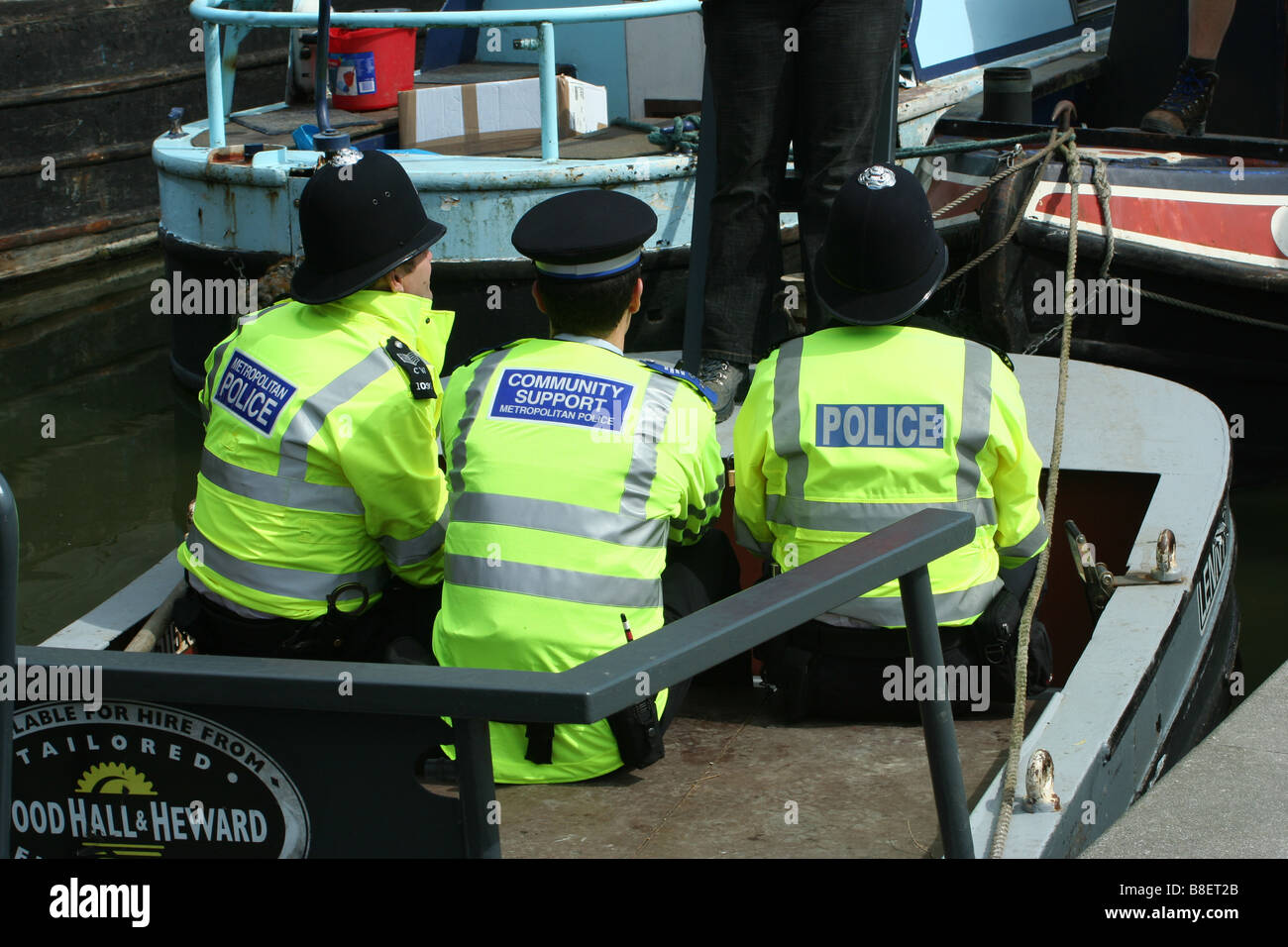 Three police men in a boat and a pair of legs Stock Photo - Alamy