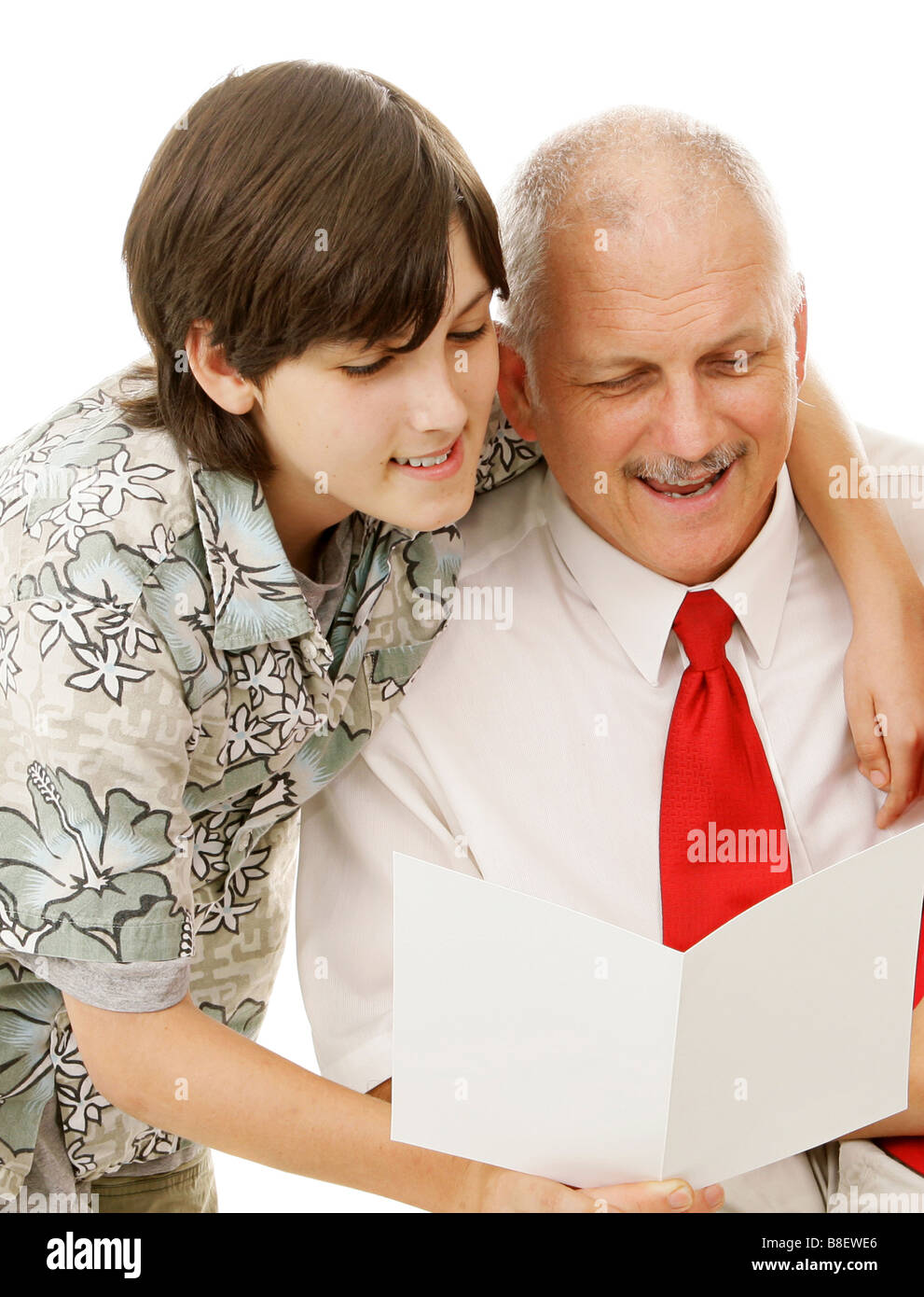 Adolescent son reading a greeting card to his father White background ...