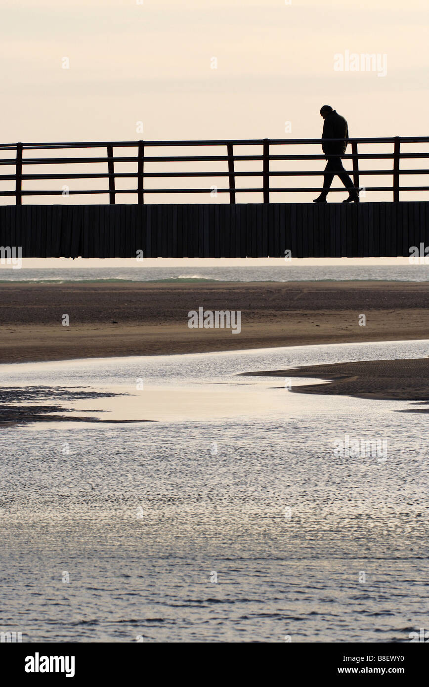 Man walking on a bridge over a river mouth Stock Photo - Alamy