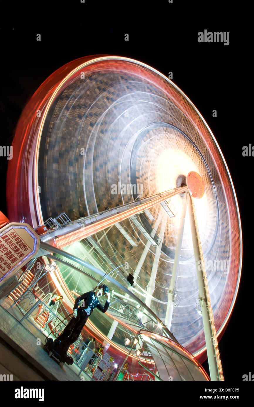 A ferris carnival wheel spinning at the funfair Stock Photo - Alamy