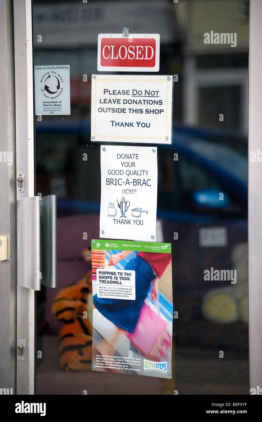 A charity advertising for donations on their shop door Stock Photo - Alamy