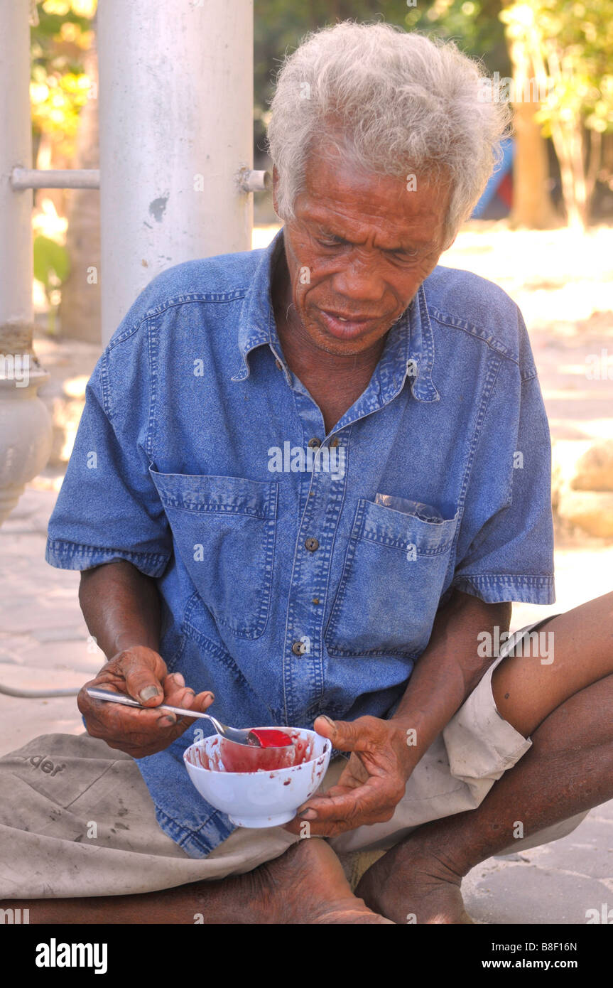 Old Moken man is eating fresh chicken blood during ritual of making ...