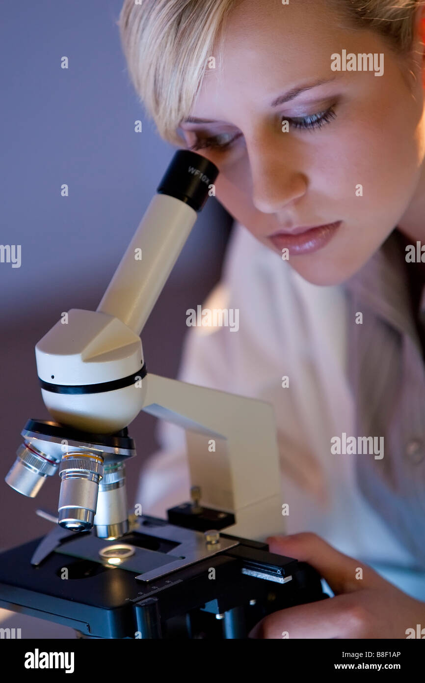 A female medical or scientific researcher using her microscope Stock ...