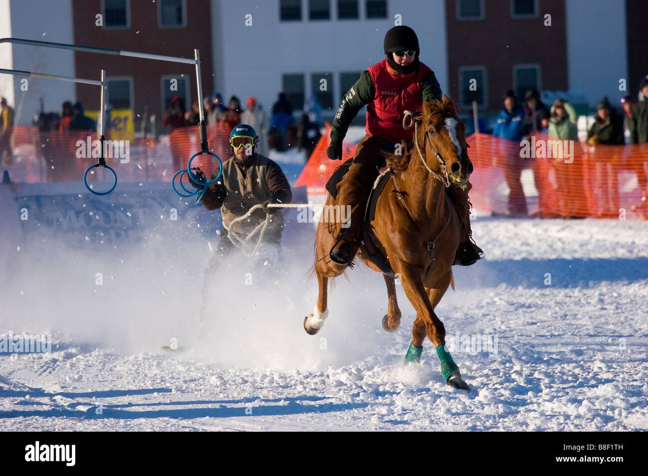 A rider on horseback pulls a skier in a winter event known as skijoring ...