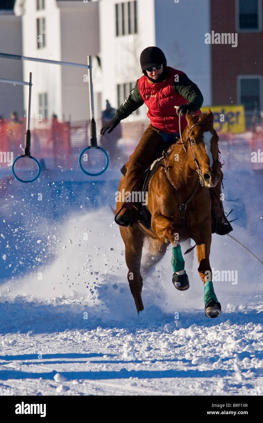 A rider on horseback pulls a skier in a winter event known as skijoring ...
