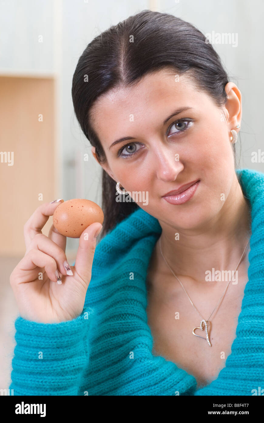 Beautiful young woman holding a raw egg Stock Photo - Alamy