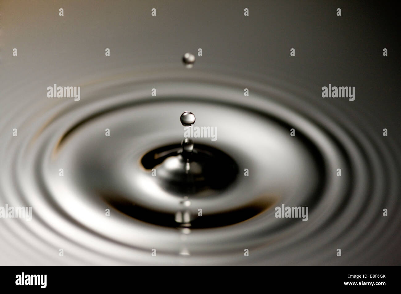 Close up of drops falling into water Stock Photo - Alamy