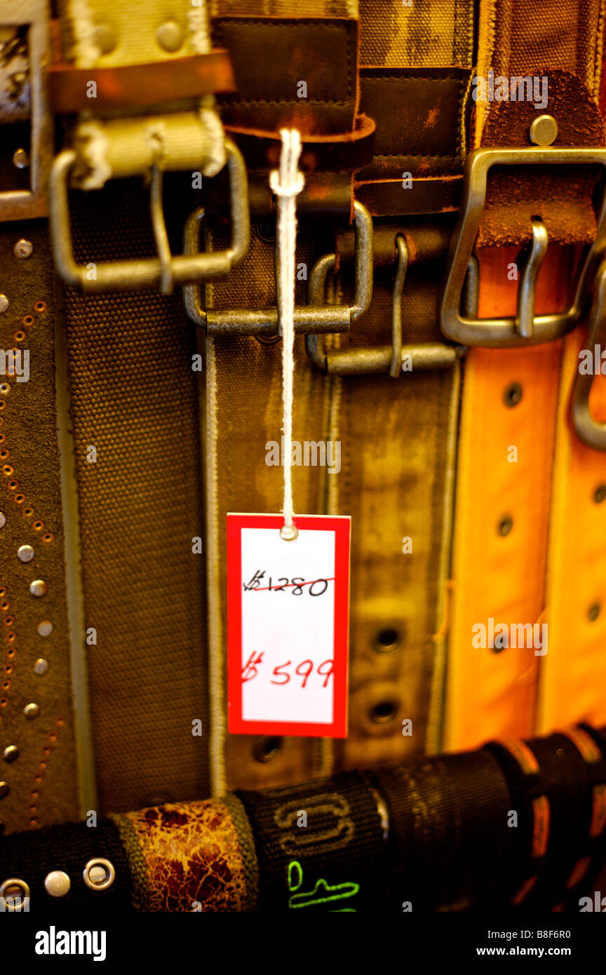 Discount price tag hanging from a belt amidst other belts Stock Photo ...