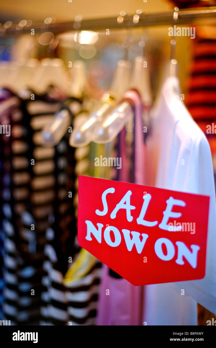 Red and white Sale sign on the window of a clothing store in front of a ...