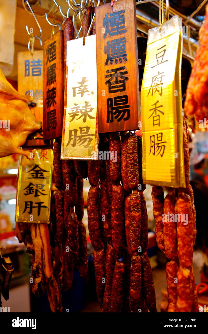 Preserved meat sausages with signs hanging from hooks on display in a ...