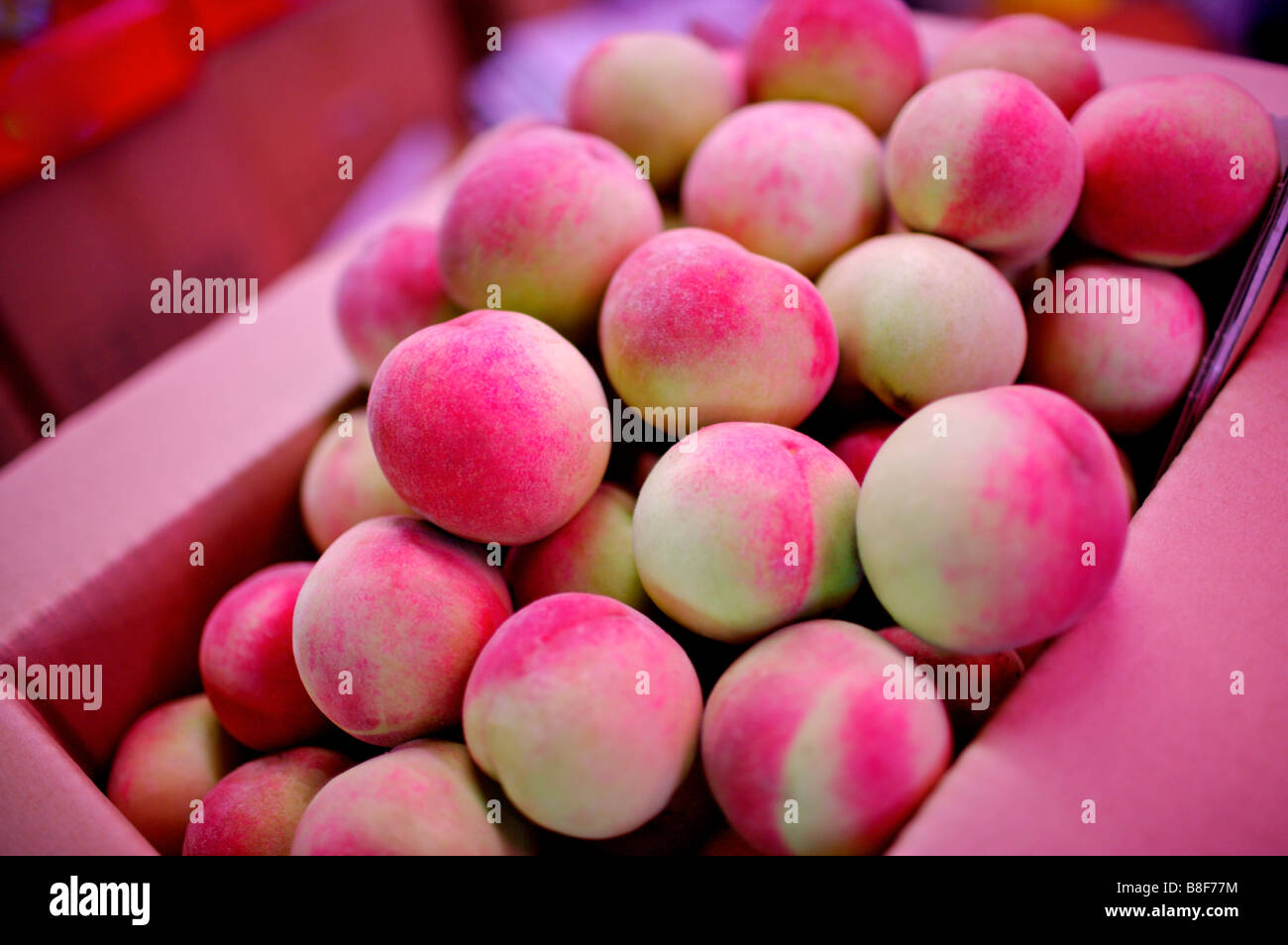 Fresh pale pink peaches in a box on display Stock Photo - Alamy