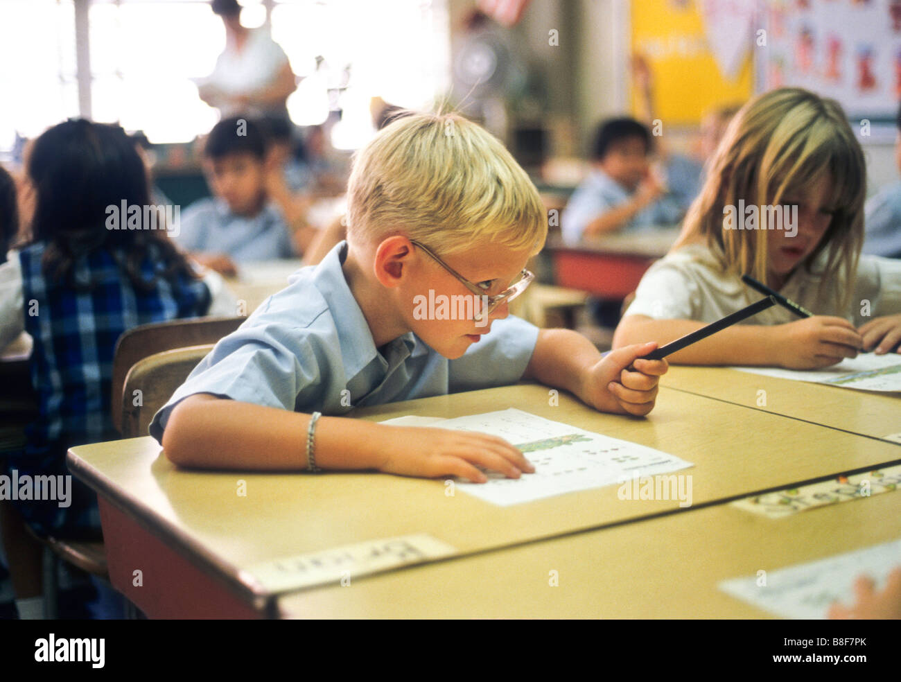 Boy checks assignment on blackboard in class as he works on school ...