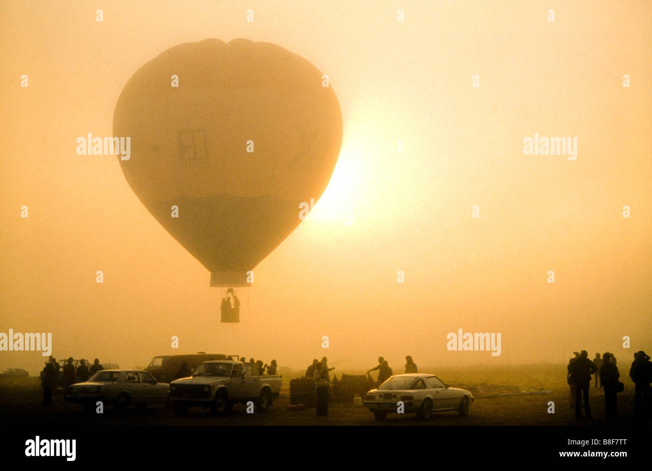 Hot air balloon rises against glow of golden rising sun, Perris ...