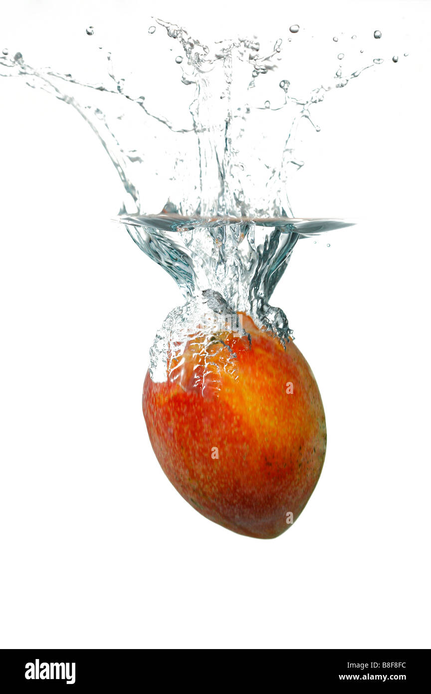 Ripe mango falling into water splashing the water Stock Photo - Alamy