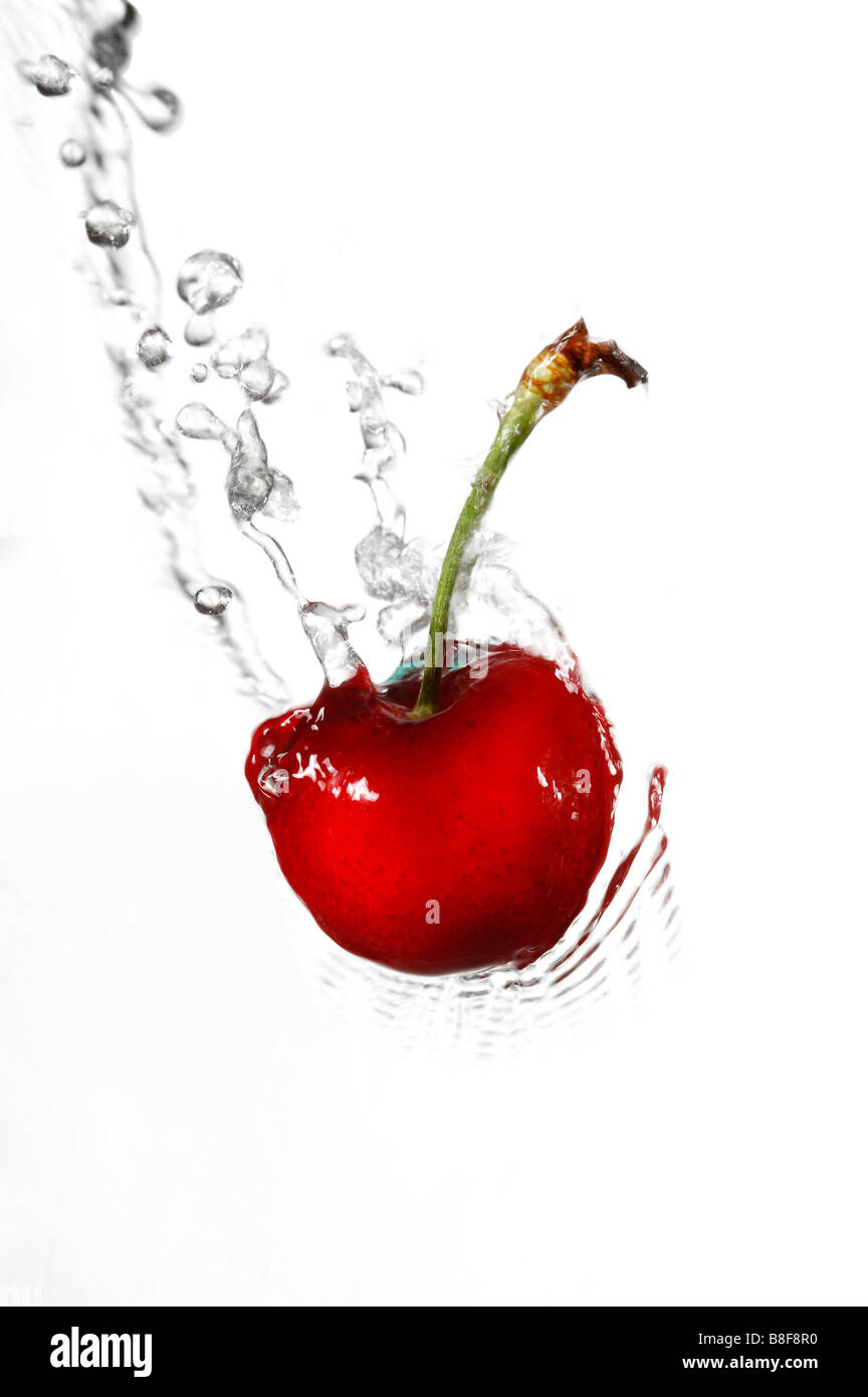 Fresh red cherry falling into water Stock Photo - Alamy