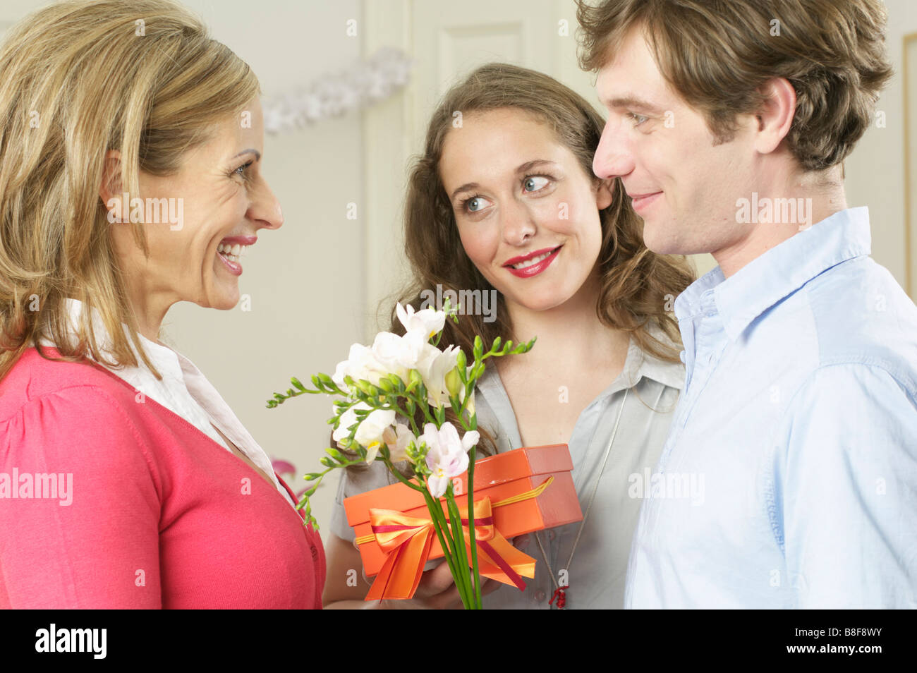 Two People giving a gift to another person Stock Photo - Alamy