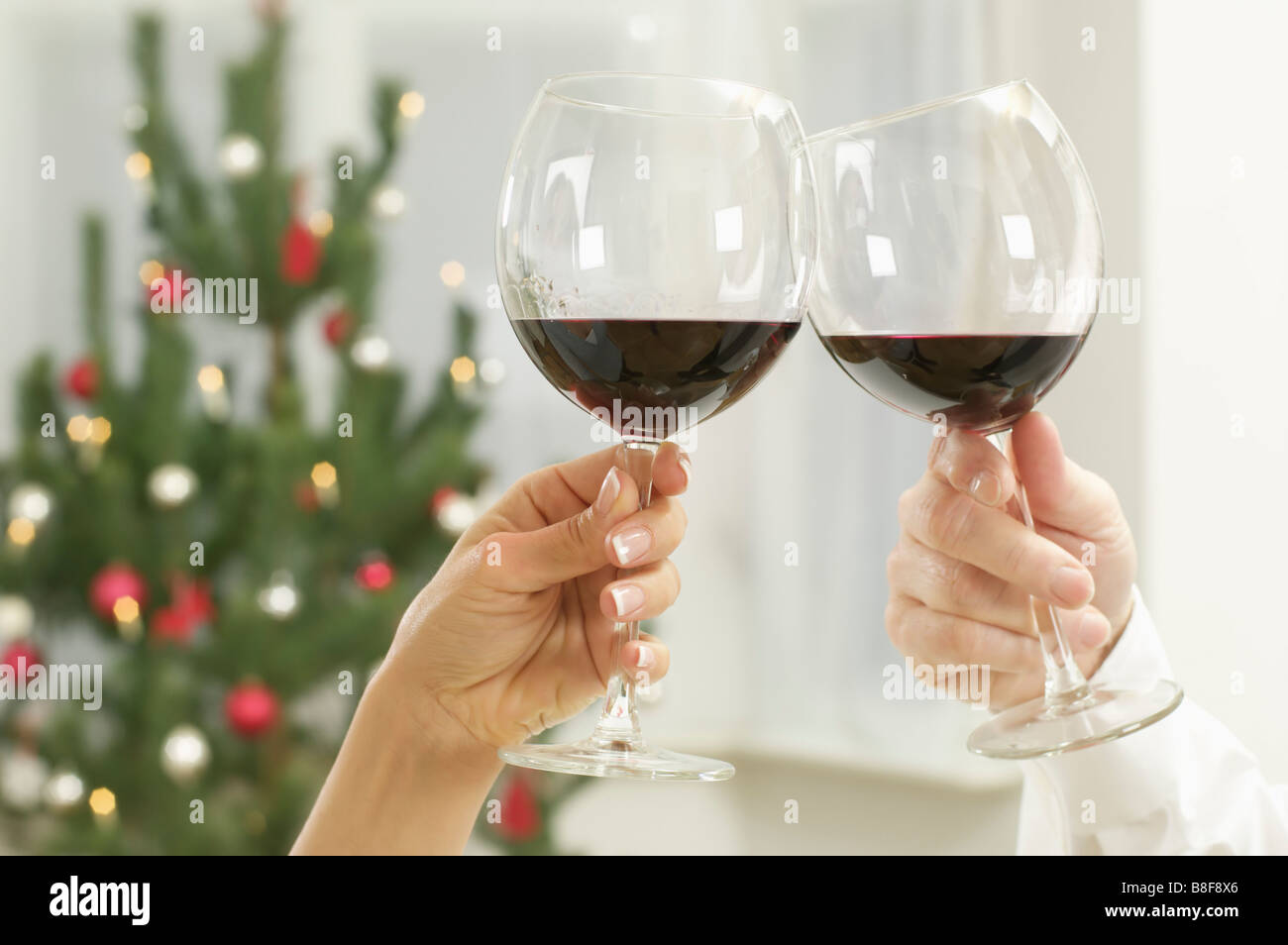 Two people chinking glasses with red wine Stock Photo - Alamy