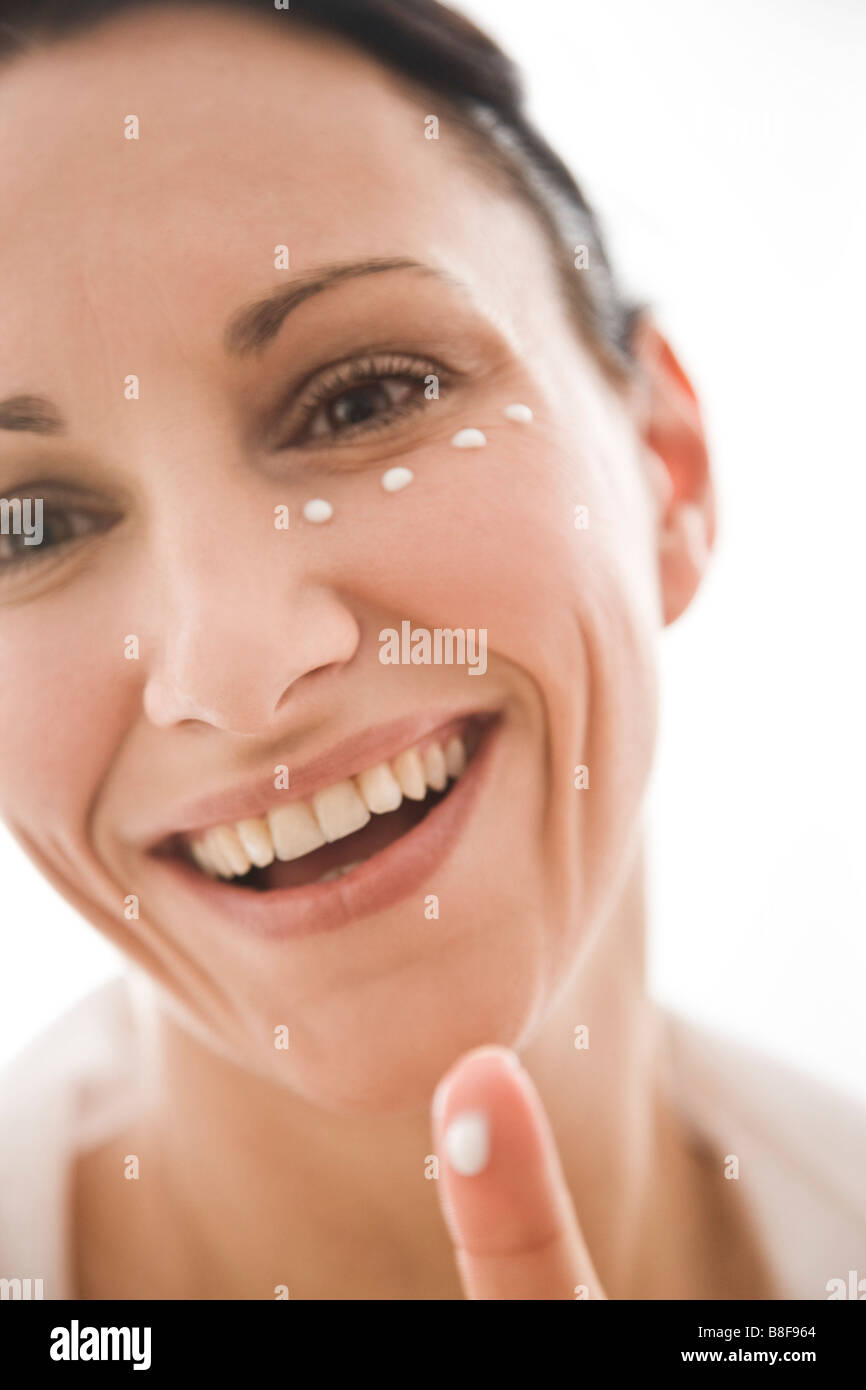 Mid adult woman face cream apply hi-res stock photography and images ...