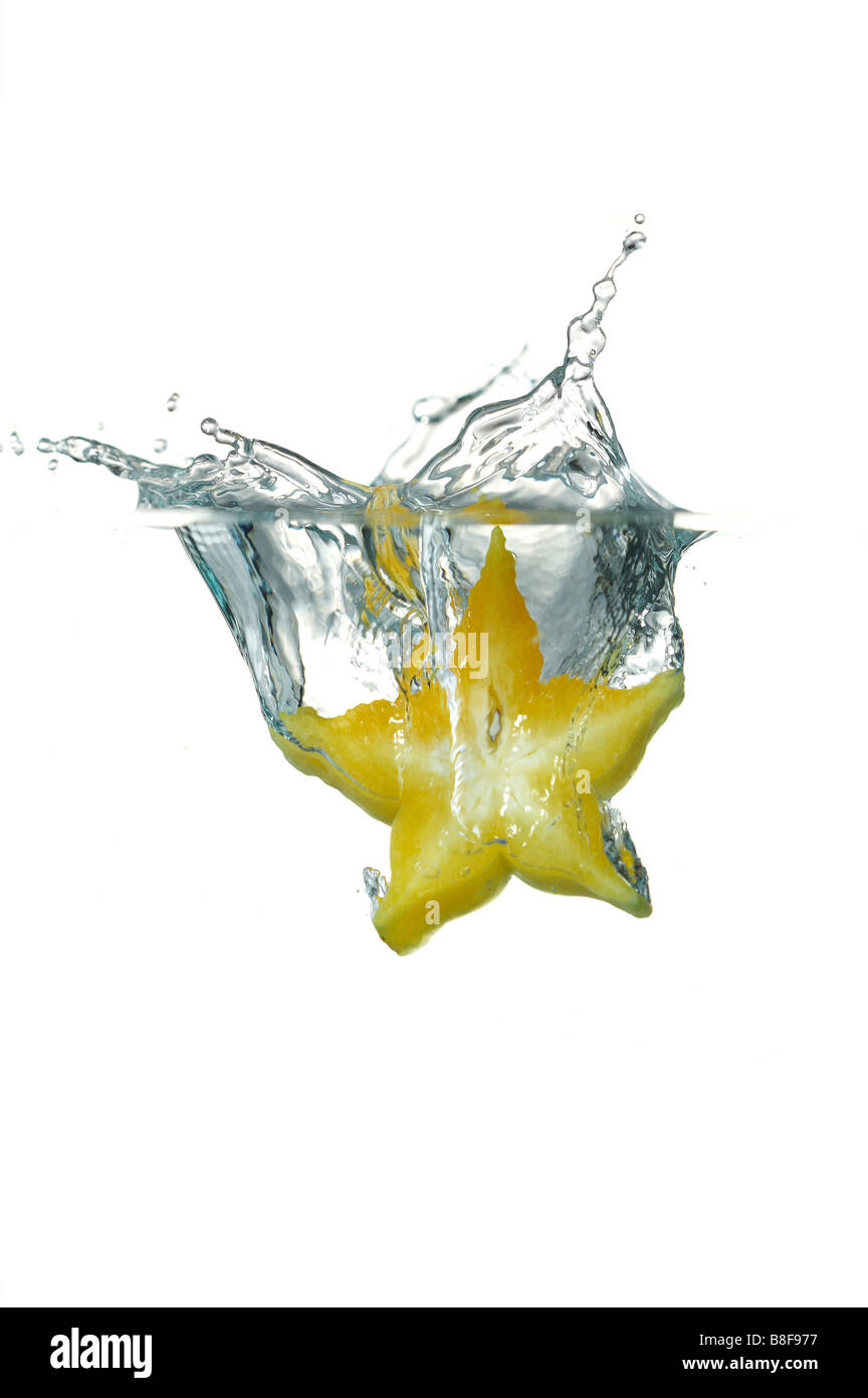 A piece of starfruit falling into water Stock Photo - Alamy