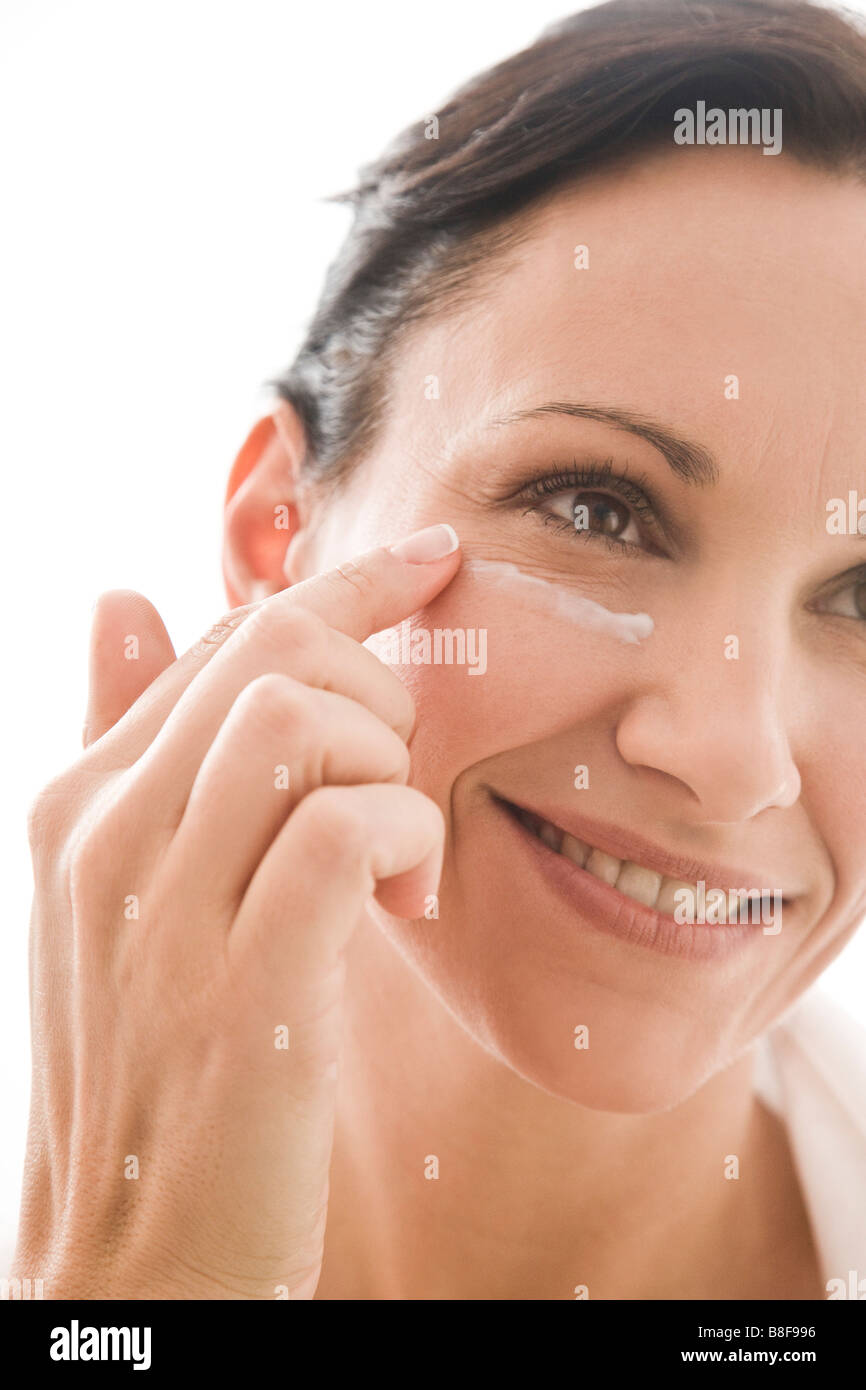 Mid adult woman face cream apply hi-res stock photography and images ...