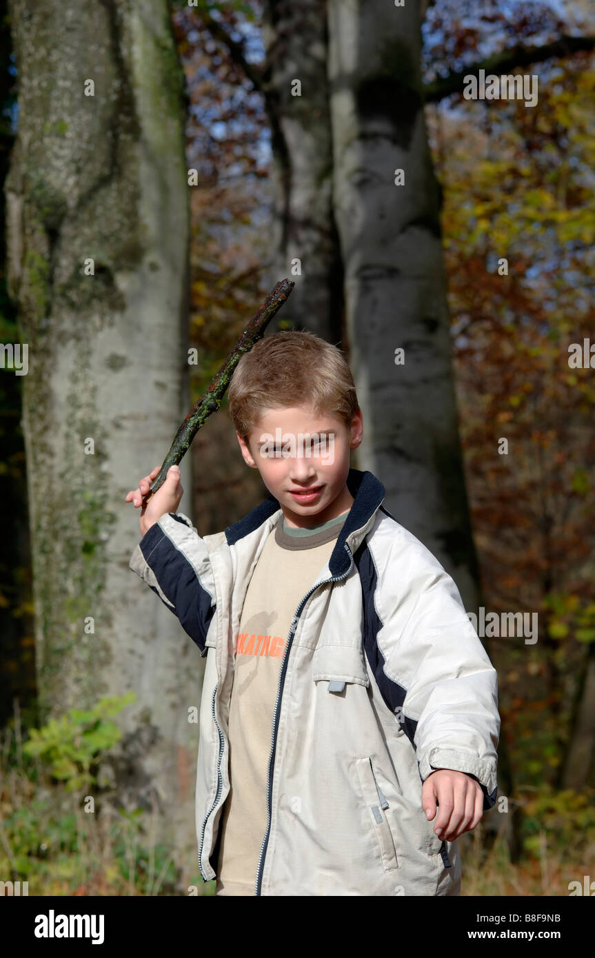 Boy holding stick ready to throw Stock Photo - Alamy
