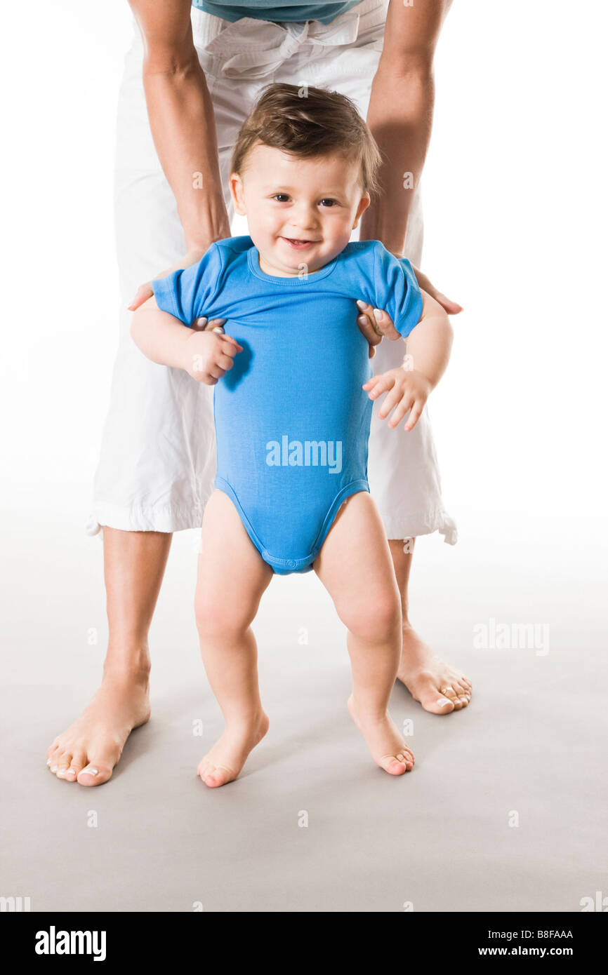 Mother teaching baby boy how to walk Stock Photo - Alamy