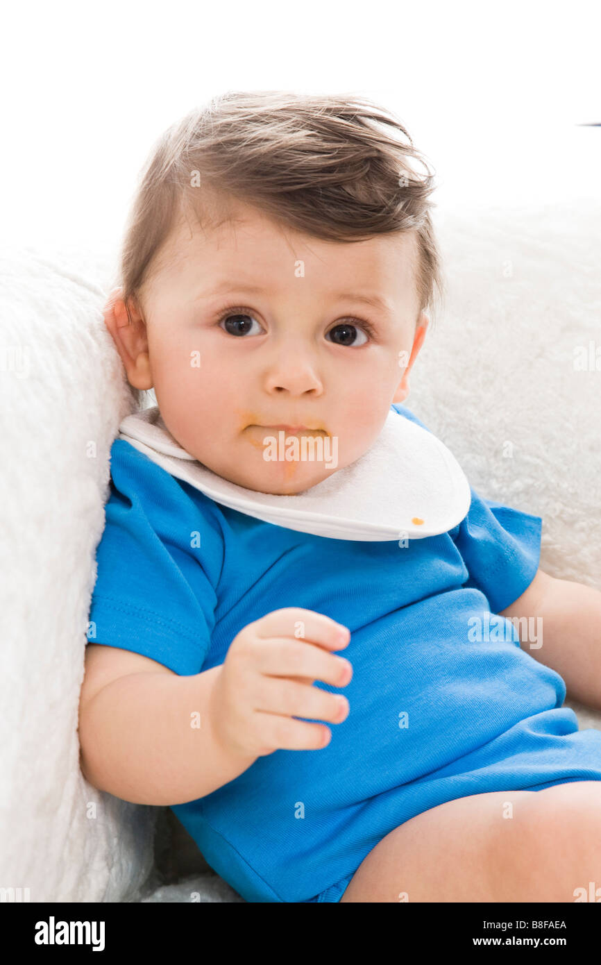 Dirty baby wearing bib during meal Stock Photo - Alamy