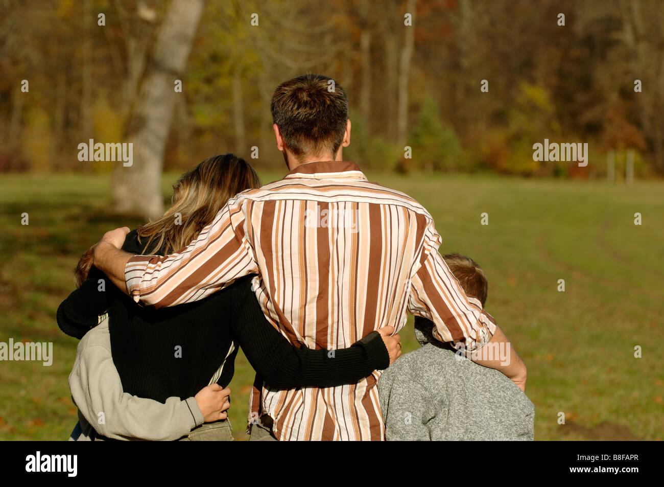 Four people embracing each other Stock Photo - Alamy
