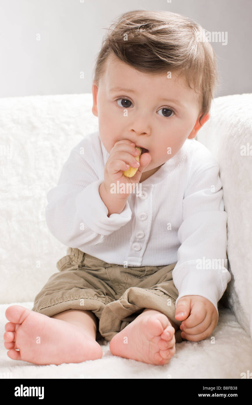 baby eating cookie on sofa Stock Photo - Alamy