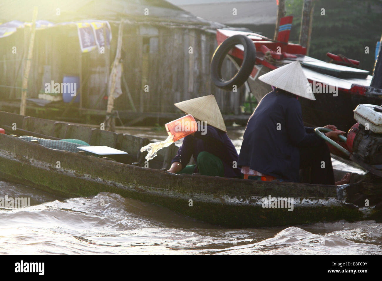 Two 2 women with traditional conical hat on their wooden boat on the ...