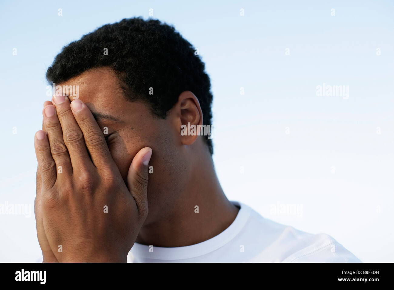 Man covering his face with his hands Stock Photo - Alamy