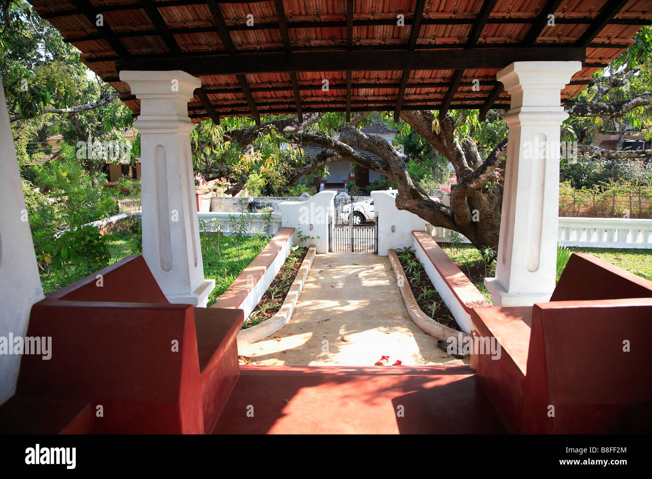 View from seating on veranda of path to entrance gate in white wall of ...