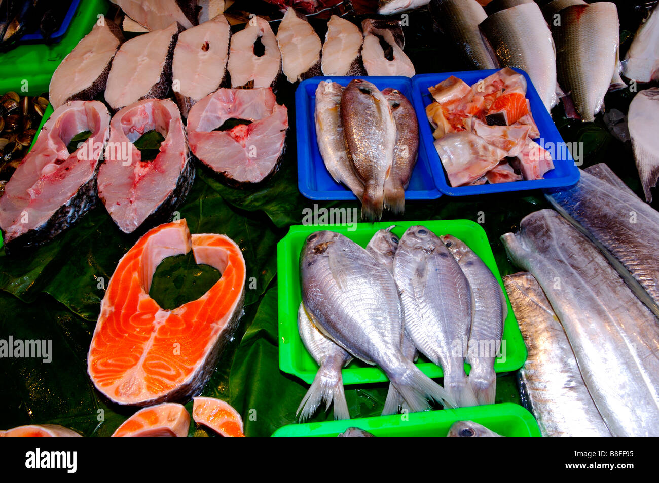 Fresh whole fish and raw fish steaks on display in a market stall Stock ...