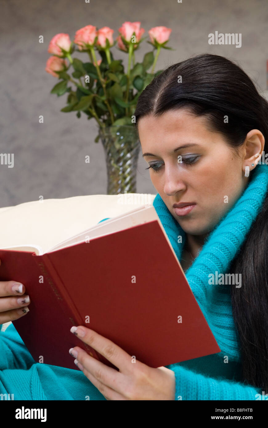 Young woman sitting reading a book Stock Photo - Alamy